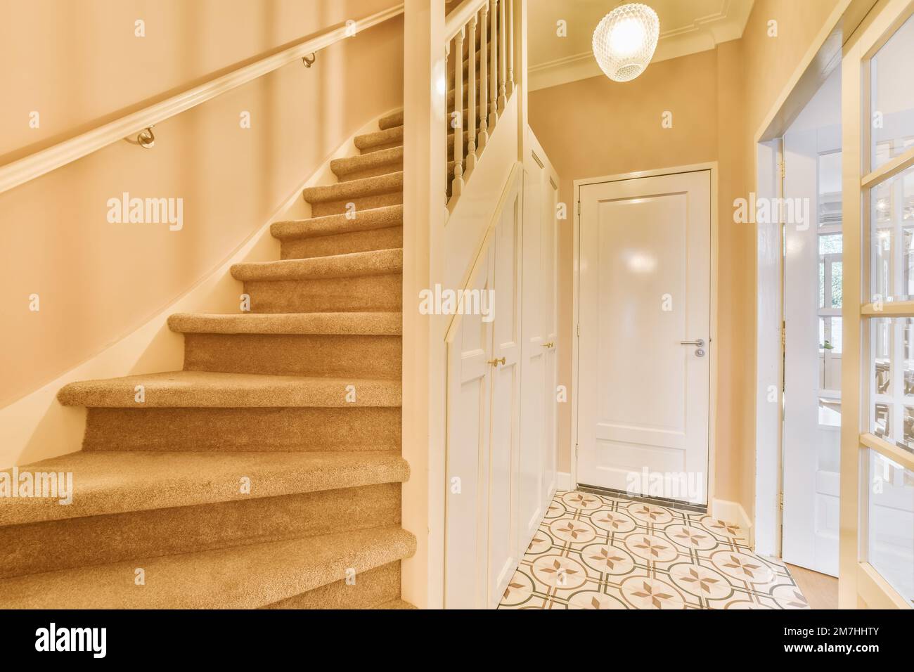 a hallway with carpet and white door handle on the left handrails are ...