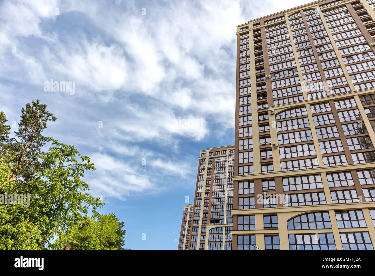 modern apartment complex. residential buildings and green trees on blue ...