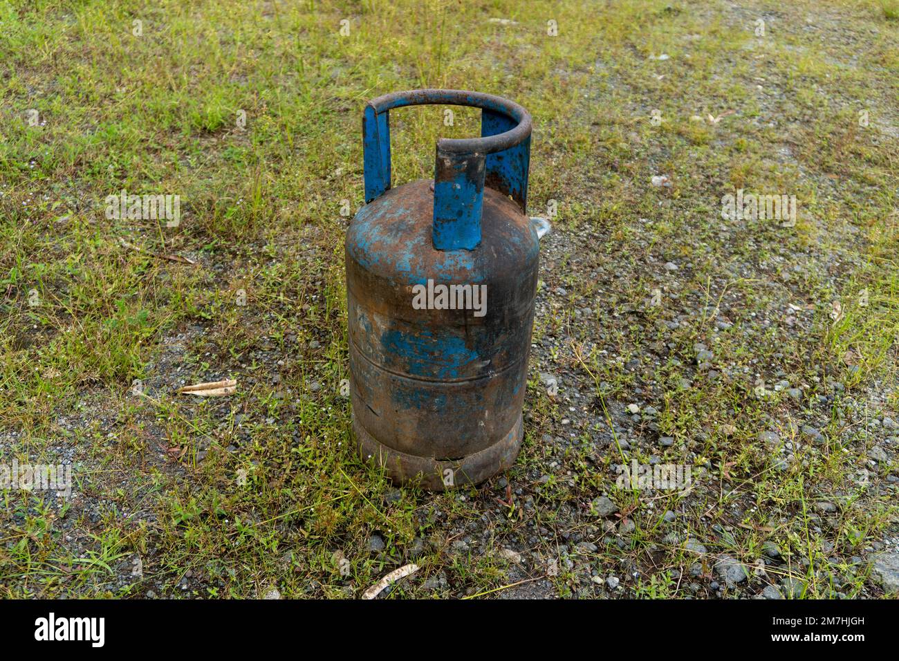 Abandoned Broken Liquid Petroleum Gas Cylinder in the middle of green ...