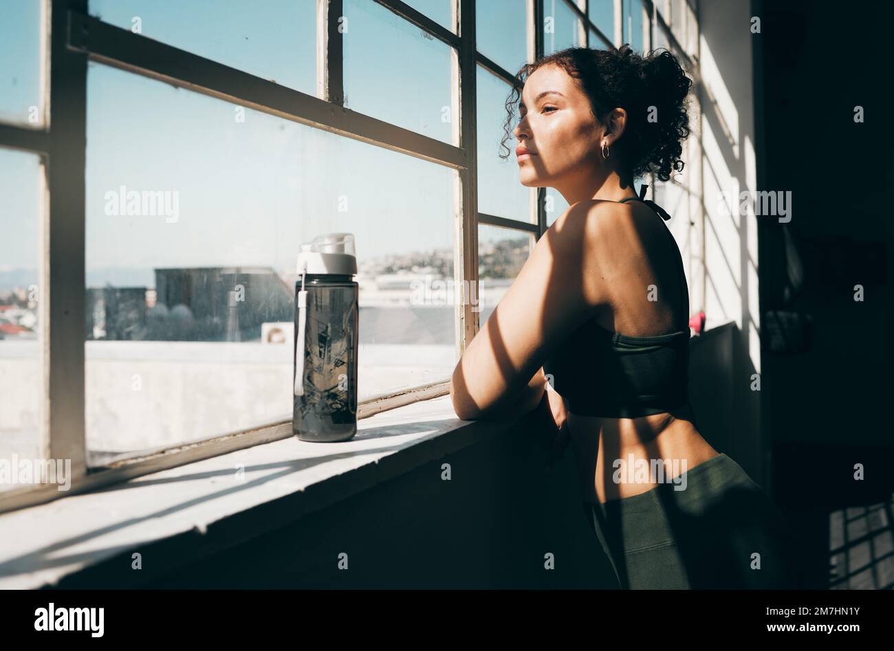 Window, fitness and relax with a sports woman looking at the view ...