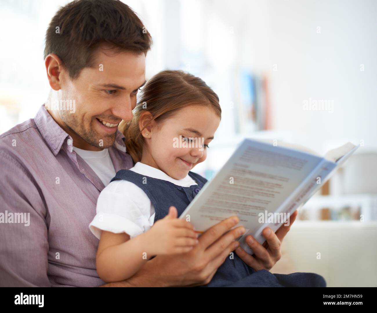 Stimulating her imagination. a young father reading a book with his ...
