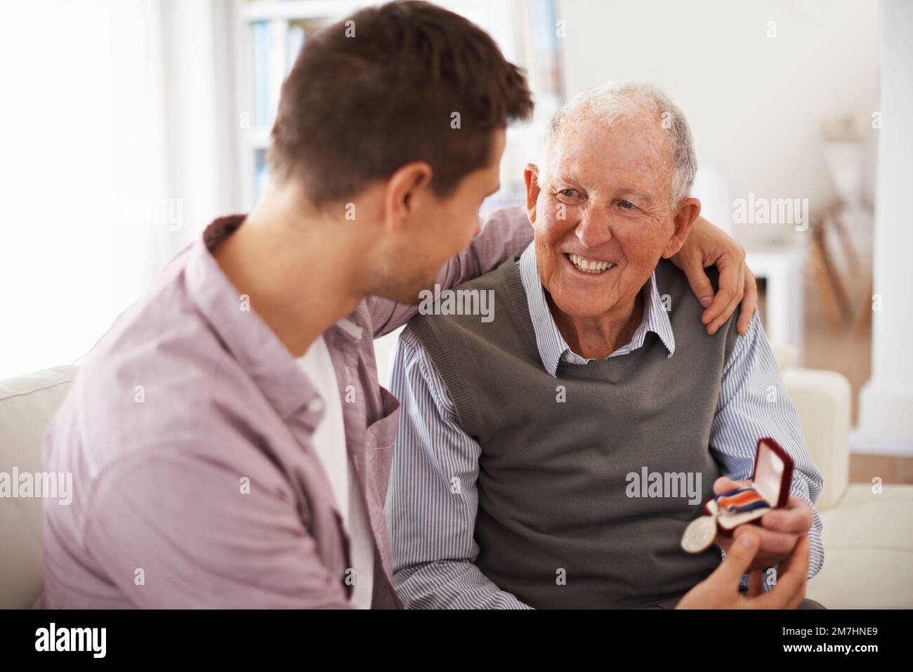 An heirloom of honor. a senior father giving his son a medal as theyre ...