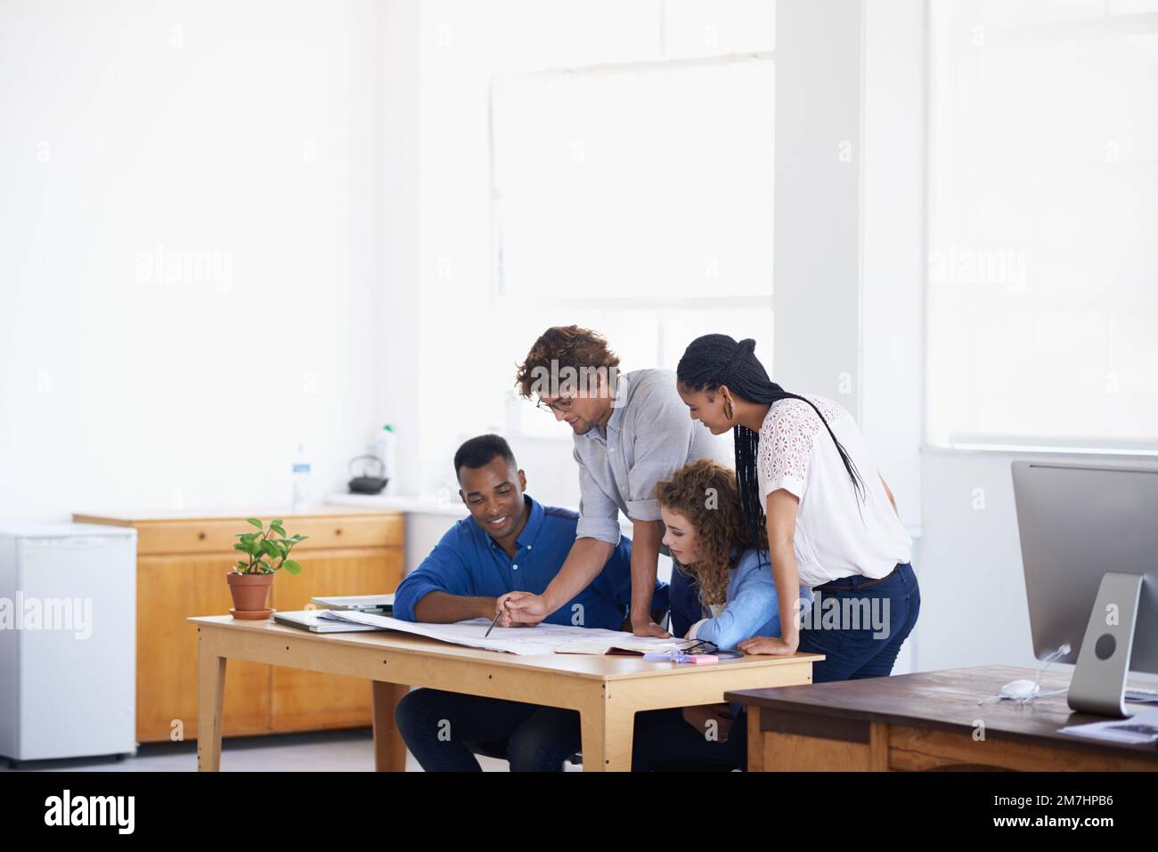 Teamwork will ensure success. A group of young coworkers discussing ...