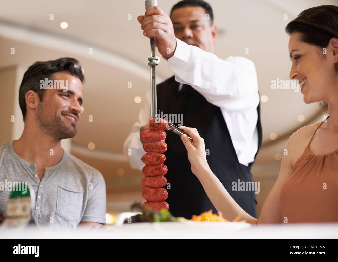 Treating his lady to a lovely lunch. A happy couple having a meat dish ...