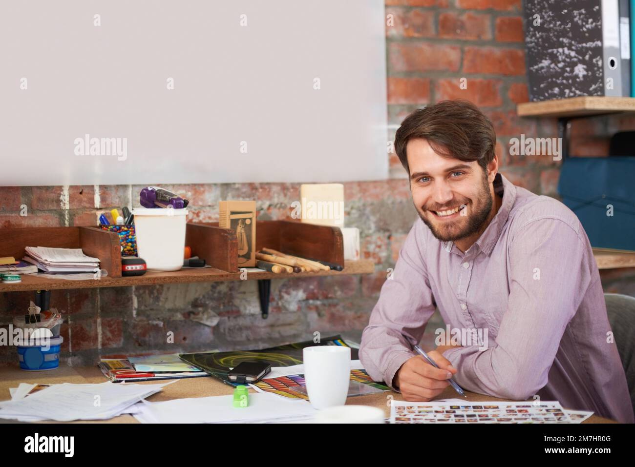 They call him, Mr Design. A handsome young designer smiling as he works ...