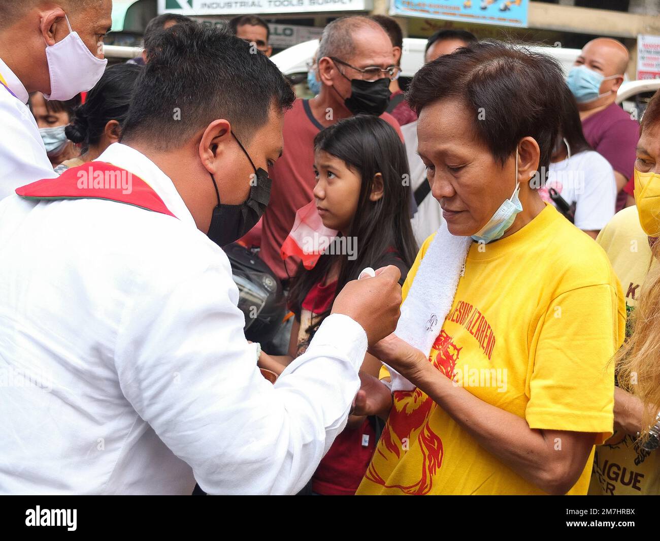 A Lay Minister hands an "Ostiya" or the communion bread to a devotee ...