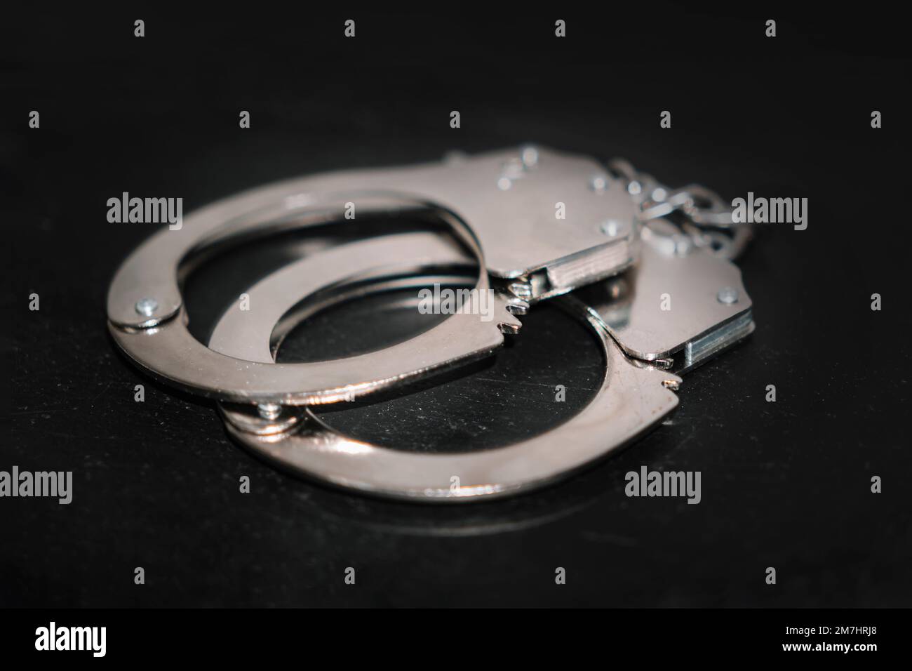 the concept of arrest and crime. metal handcuffs on a black table ...