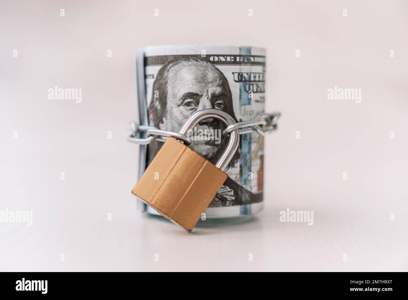 money dollars in a chain with a lock on the background of white. The ...