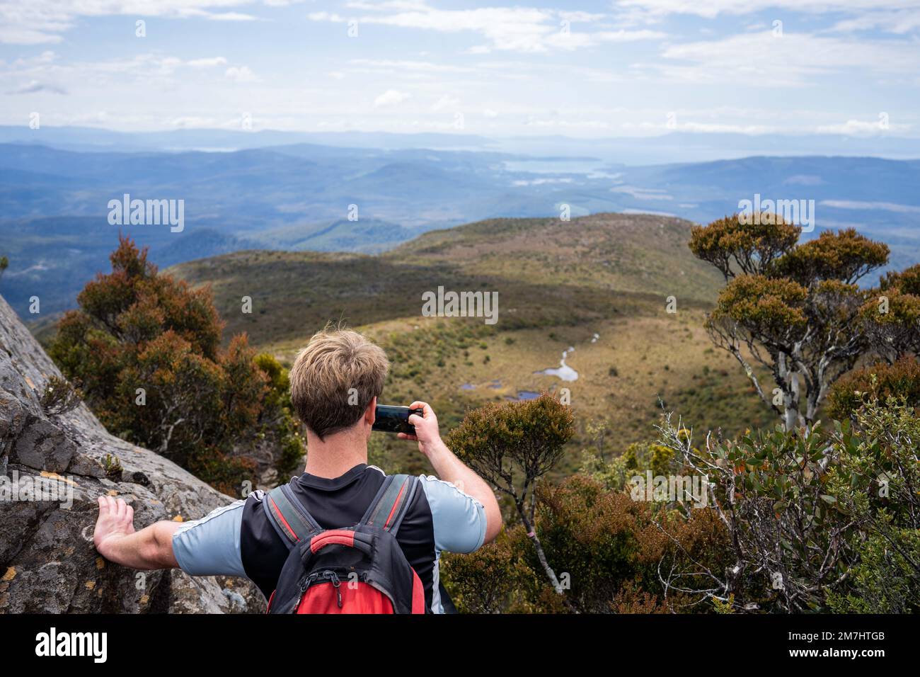 taking a photo on top of a mountain peak. using a phone in nature ...