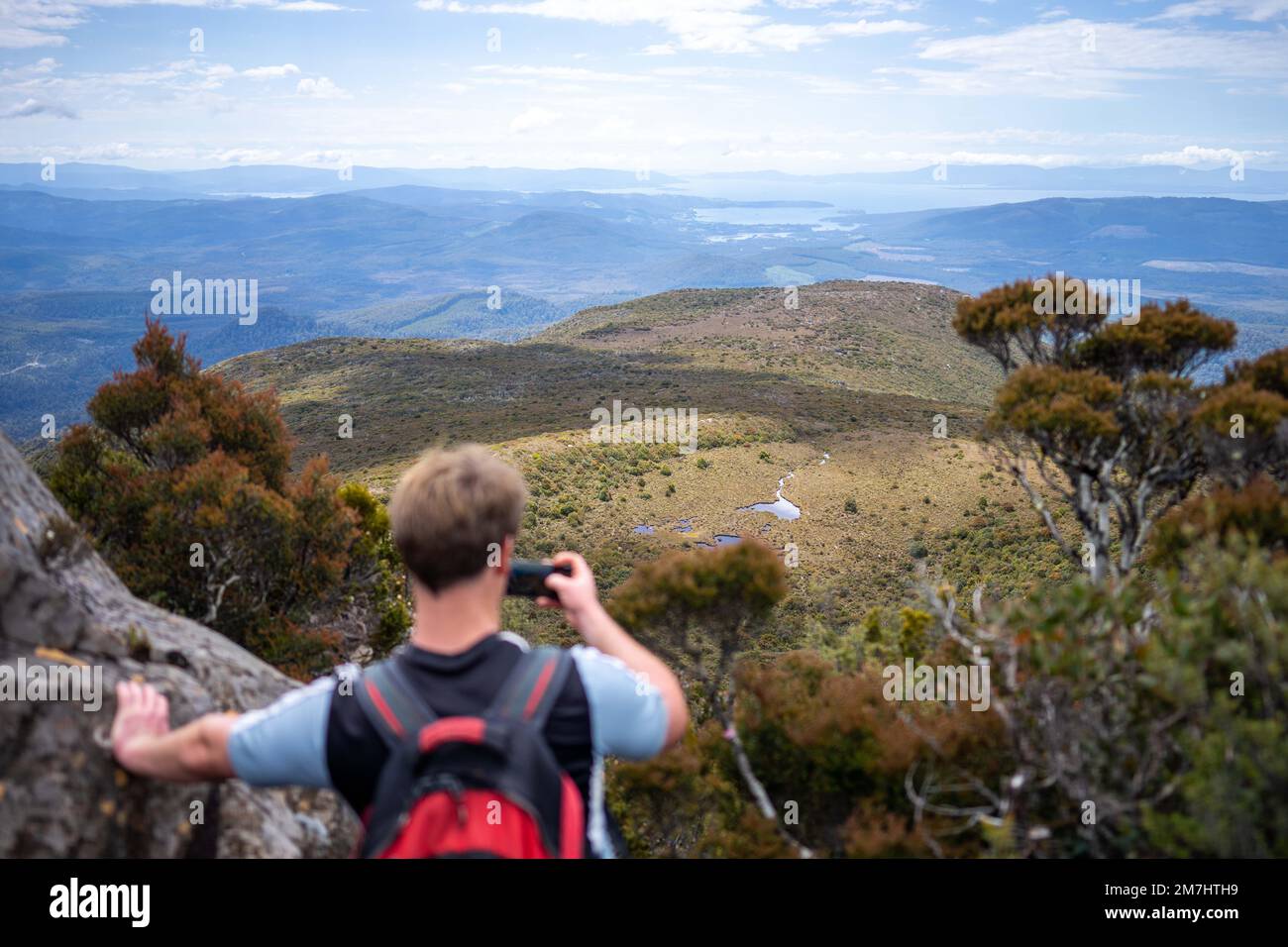 taking a photo on top of a mountain peak. using a phone in nature ...
