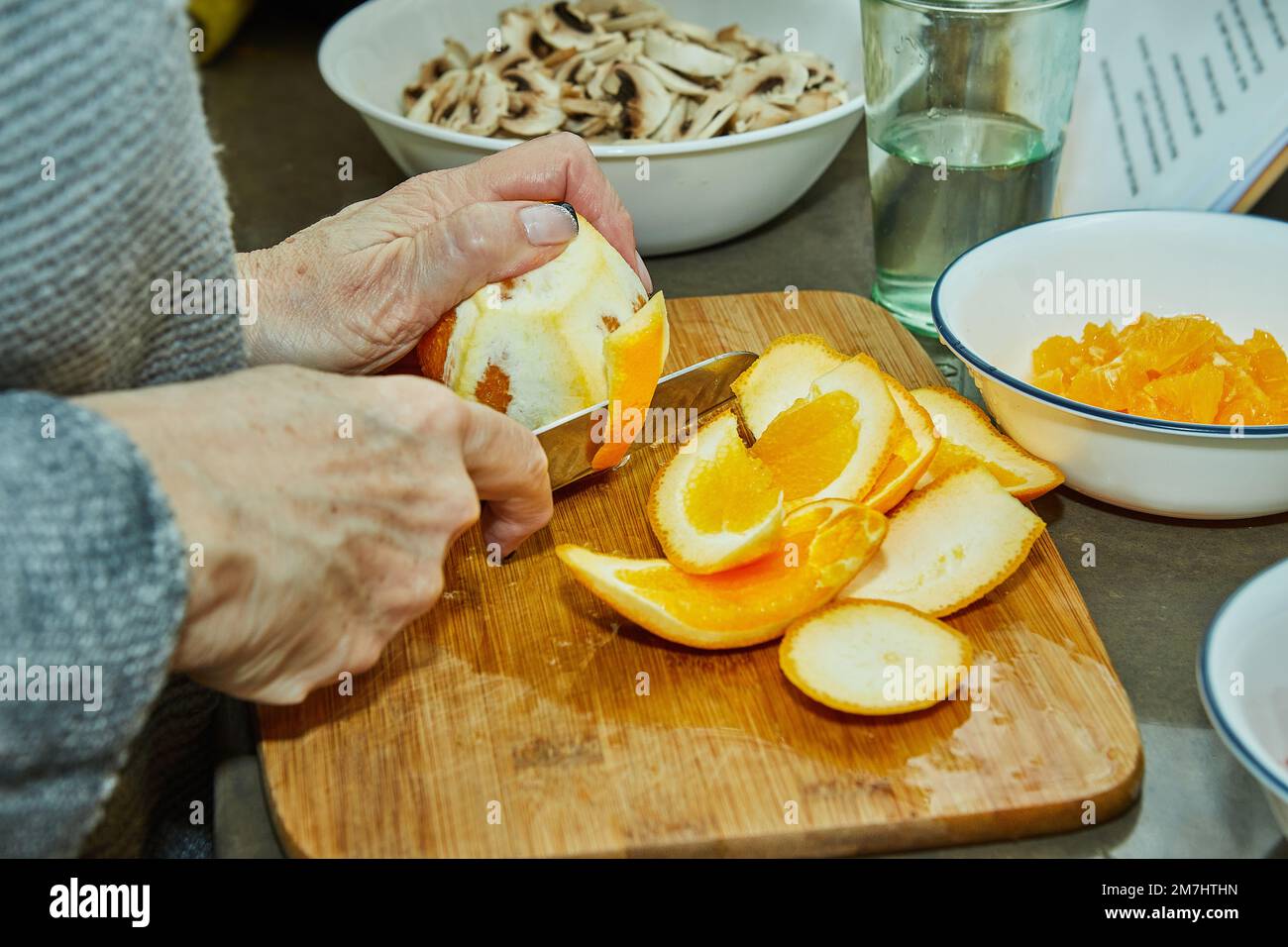 Chef cuts oranges to prepare salad with zucchini, oranges and salami ...