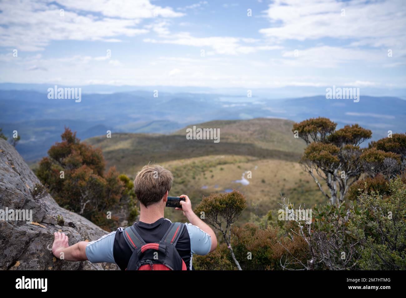 taking a photo on top of a mountain peak. using a phone in nature ...