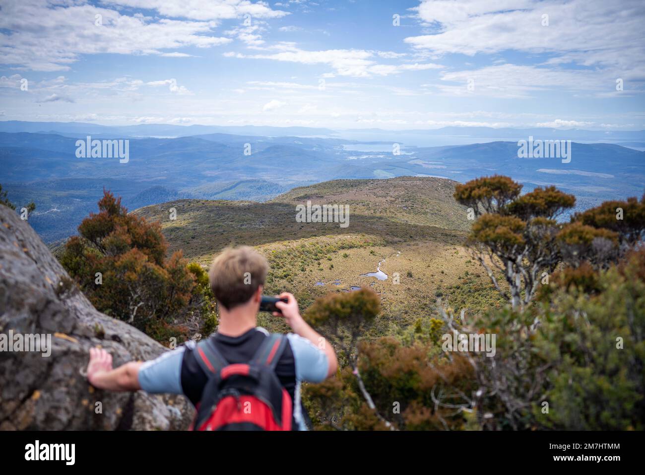 taking a photo on top of a mountain peak. using a phone in nature ...