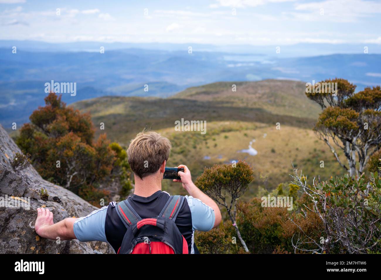taking a photo on top of a mountain peak. using a phone in nature ...