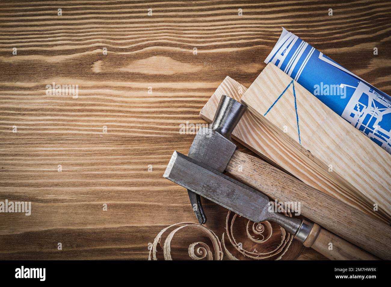 Blue blueprint claw hammer chisel wooden studs curled shavings on wood ...