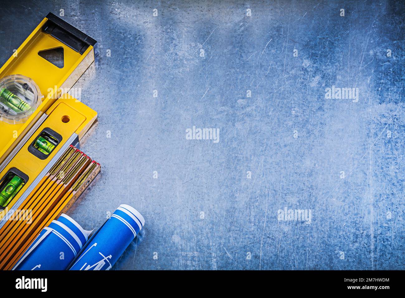 Blue blueprints levels yellow wooden meter on metallic surface Stock ...