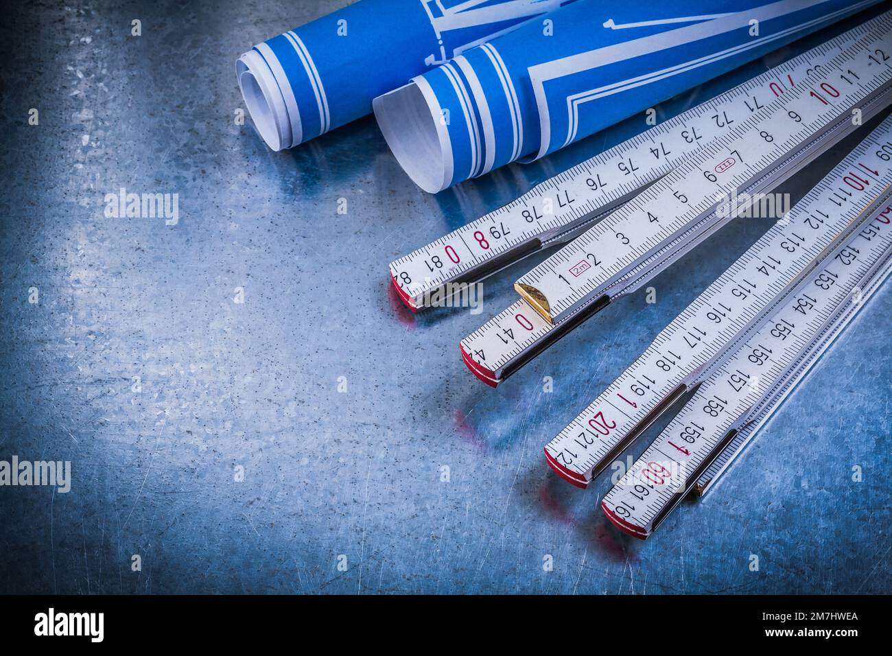 Blue blueprints wooden meter on metallic background maintenance concept ...