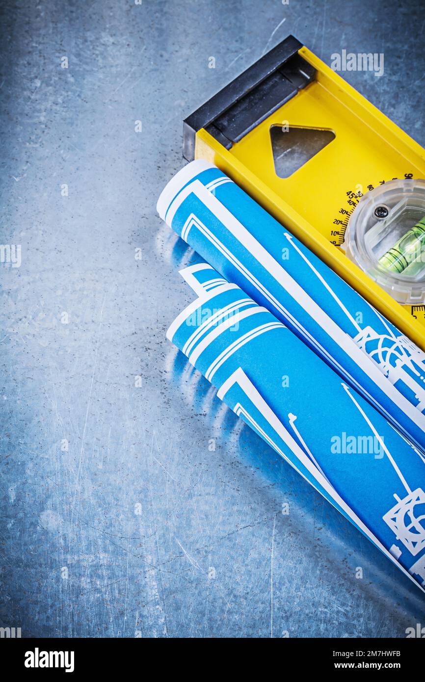 Blue construction drawings level on metallic background maintenance ...