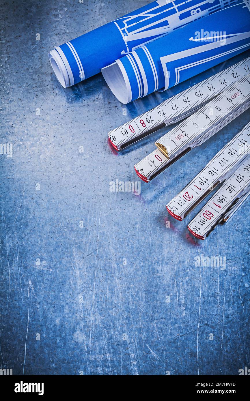 Blue blueprints wooden meter on metallic background construction ...