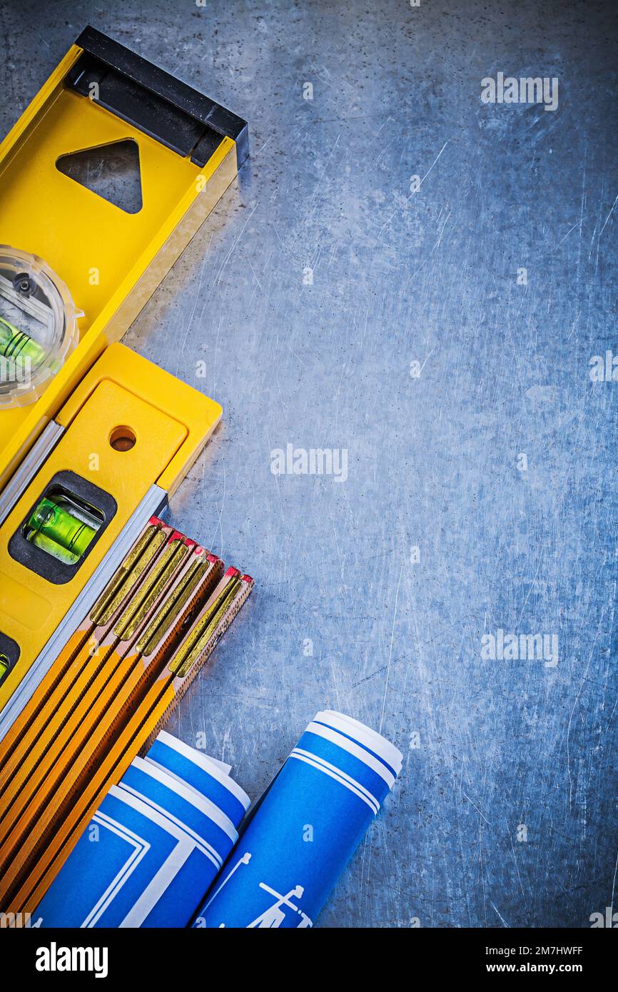 Blue construction drawings levels yellow wooden meter on metallic ...