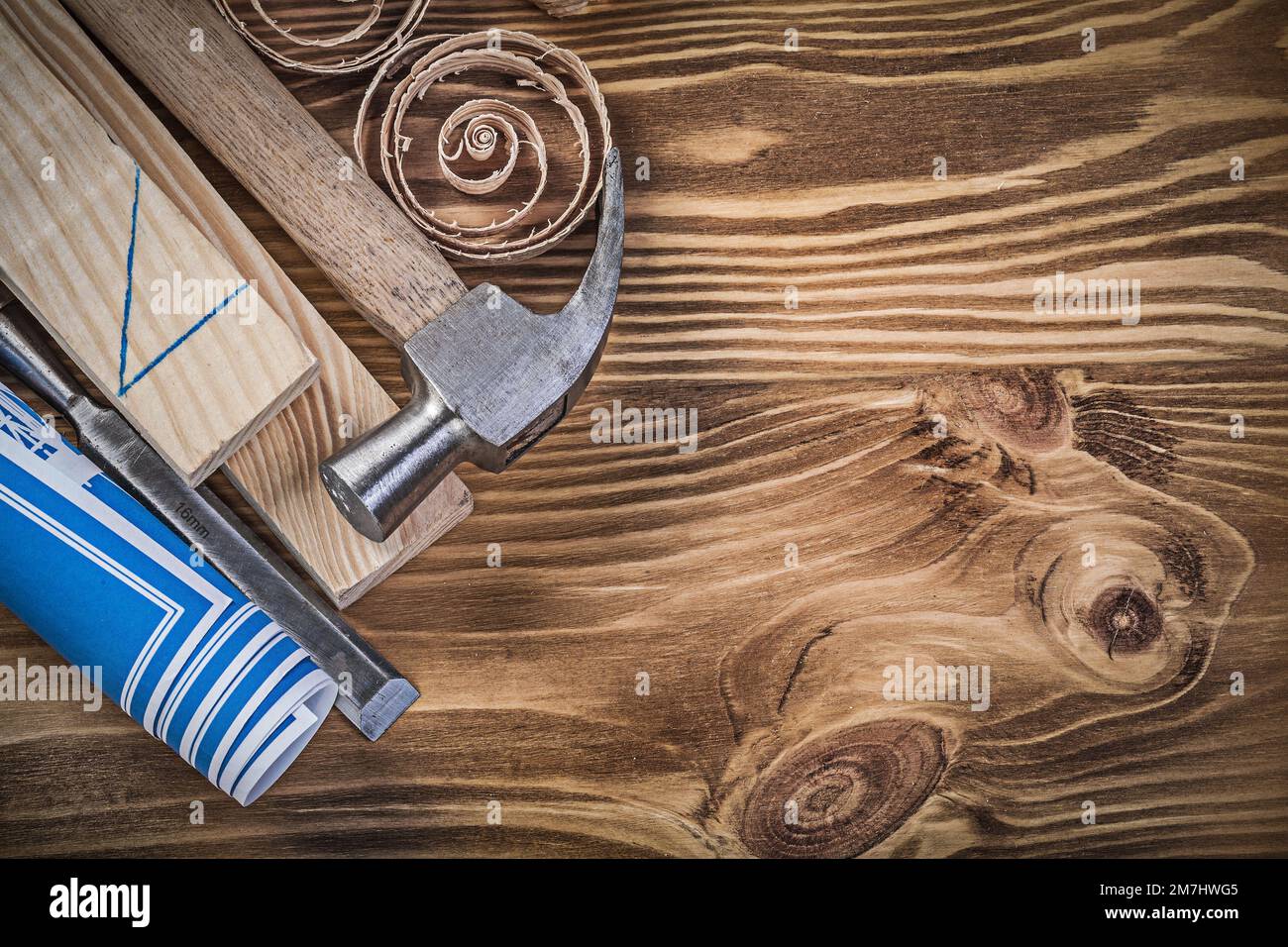 Blue construction plan claw hammer flat chisel wooden studs shavings on ...