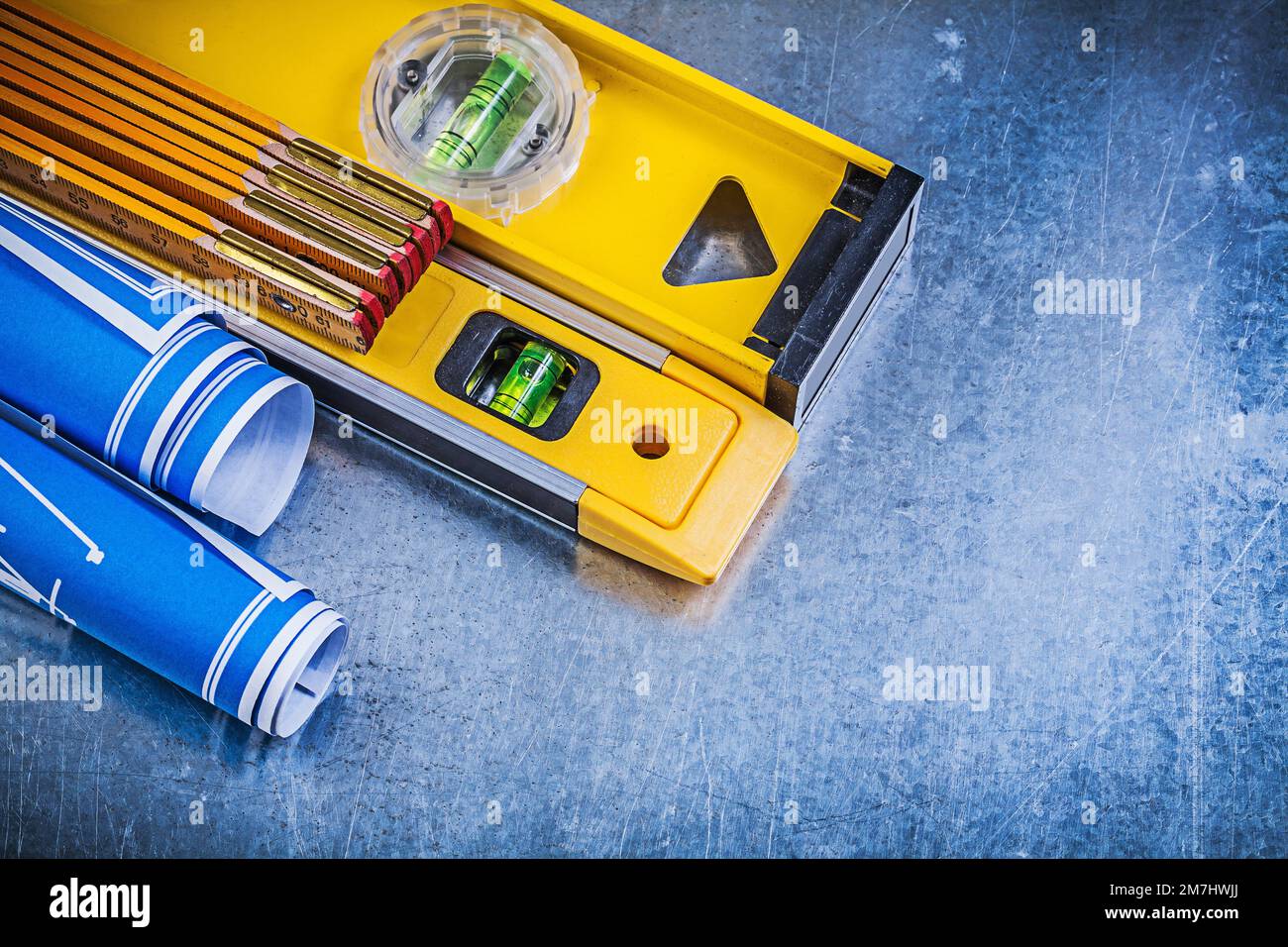 Blue construction plans levels yellow wooden meter on metallic ...