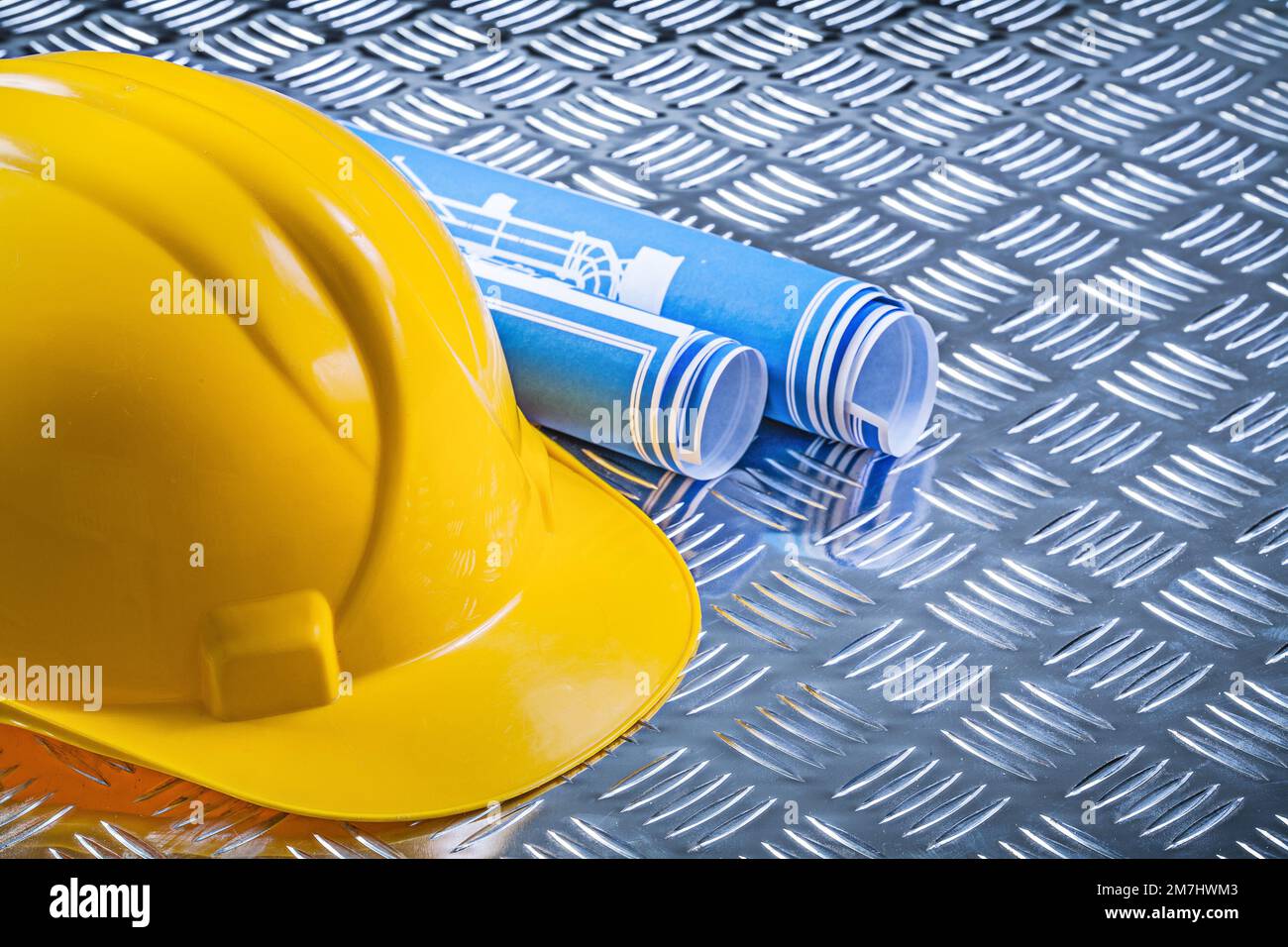 Blue engineering drawings hard hat on corrugated metal background ...