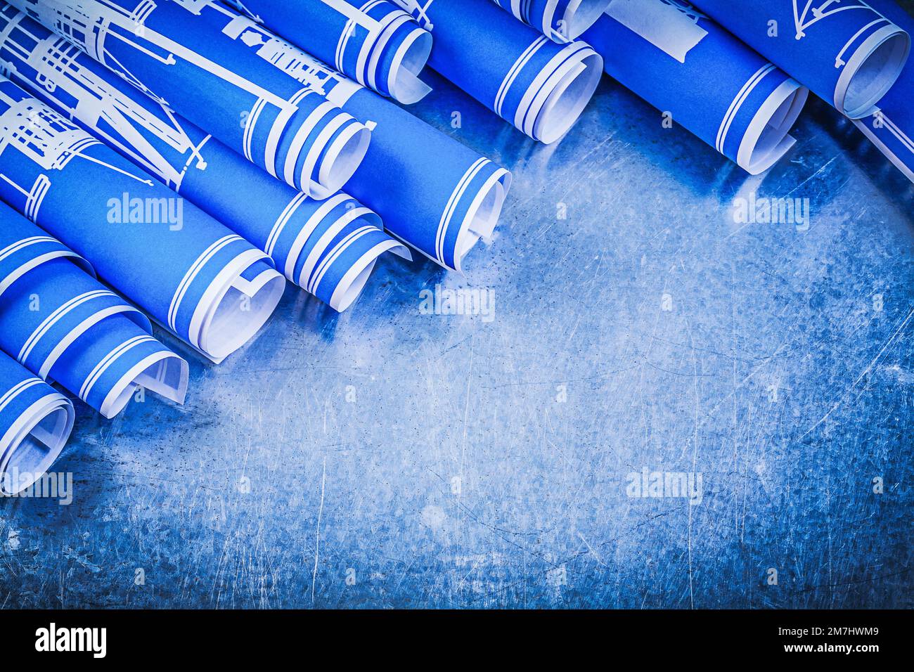 Blue engineering drawings on metallic background directly above ...