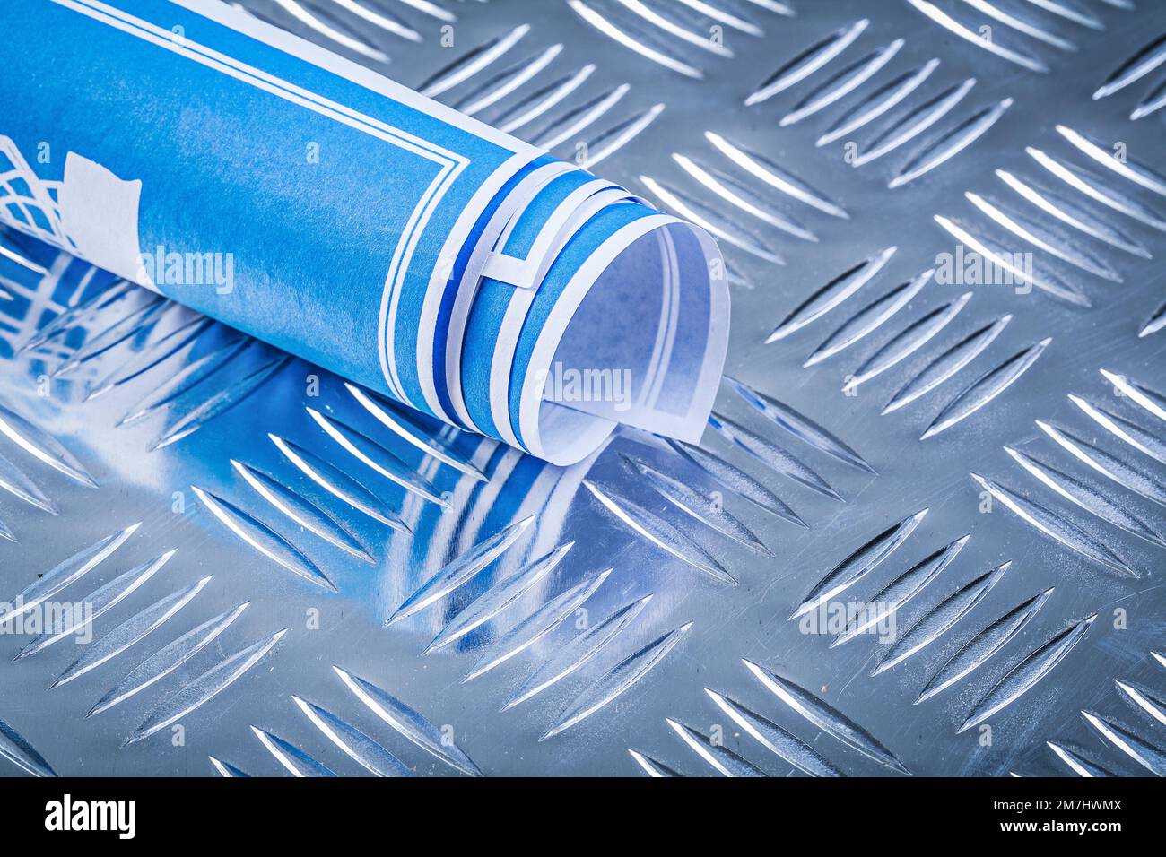 Blue rolled blueprints on corrugated metal background construction ...