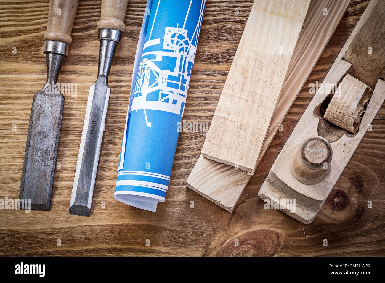 Blue rolled construction drawing shaving plane chisels wooden studs on ...
