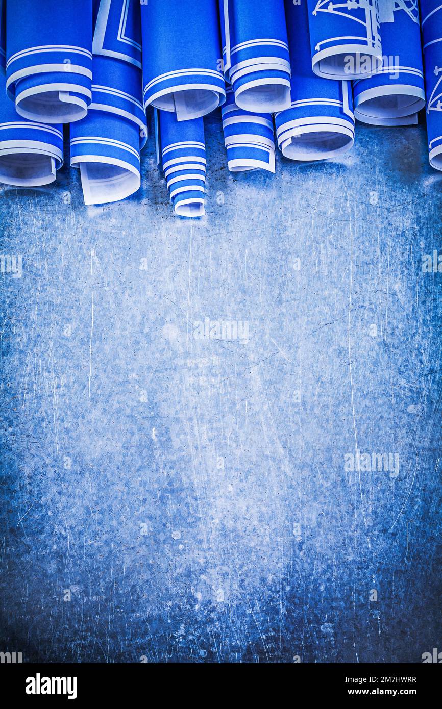 Blue rolled up blueprints on metallic background copy space ...