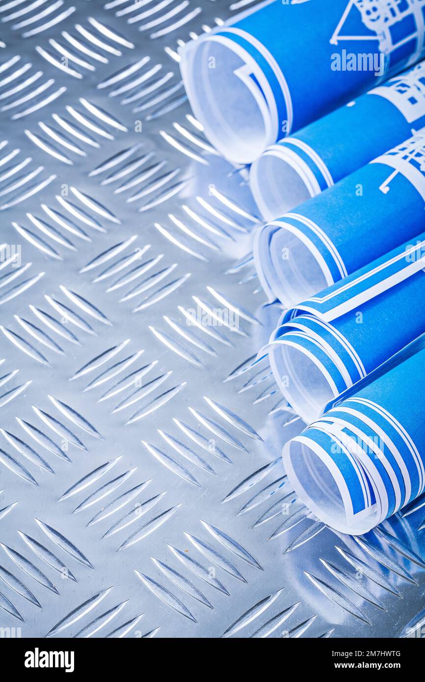 Blue rolled up construction drawings on fluted metal background ...