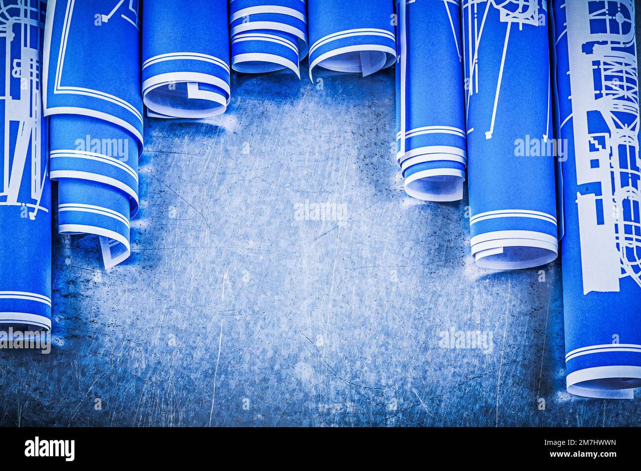 Blue rolled engineering drawings on metallic background construction ...
