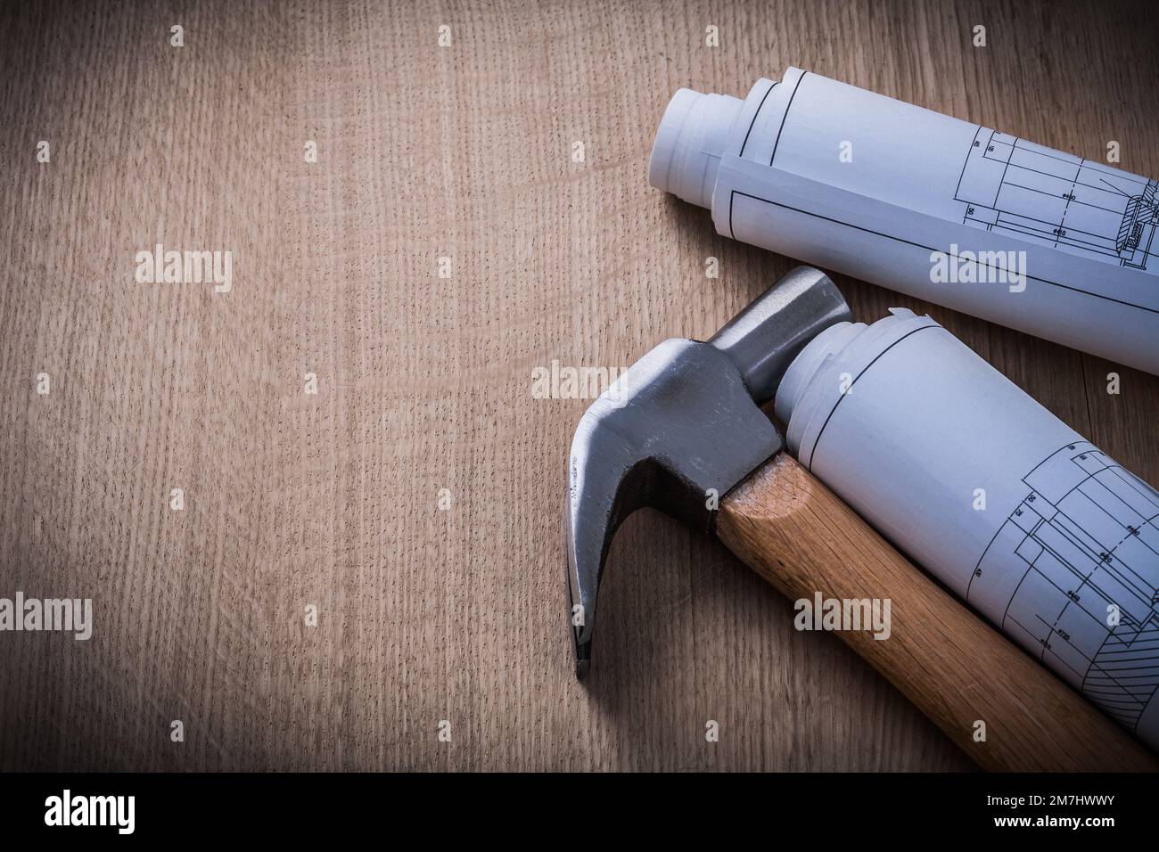 Blueprint rolls claw hammer on wooden background construction concept ...
