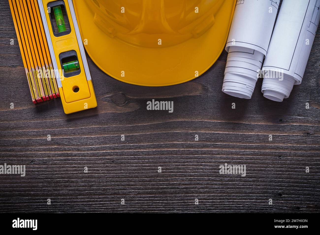 Blueprints yellow construction level building helmet and wooden meter ...