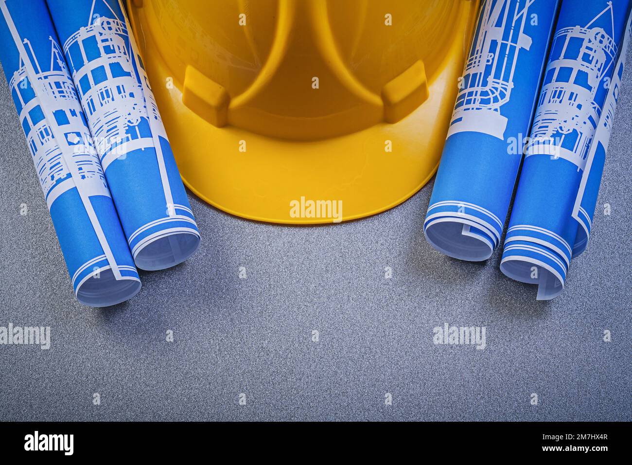 Building helmet blue rolled blueprints on grey background construction ...
