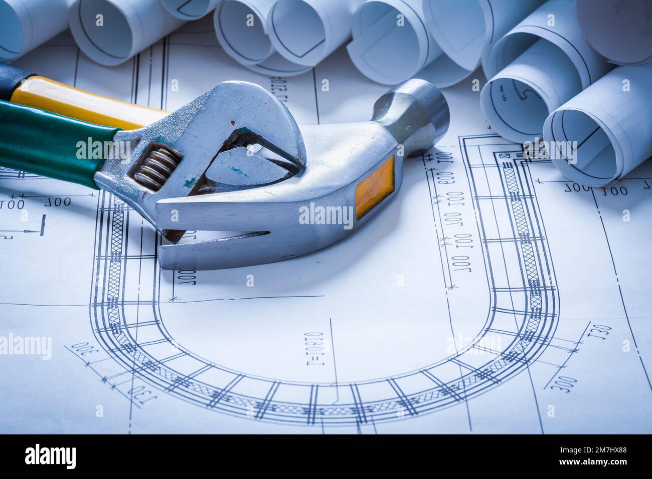 Claw hammer adjustable spanner and blueprint rolls construction concept ...