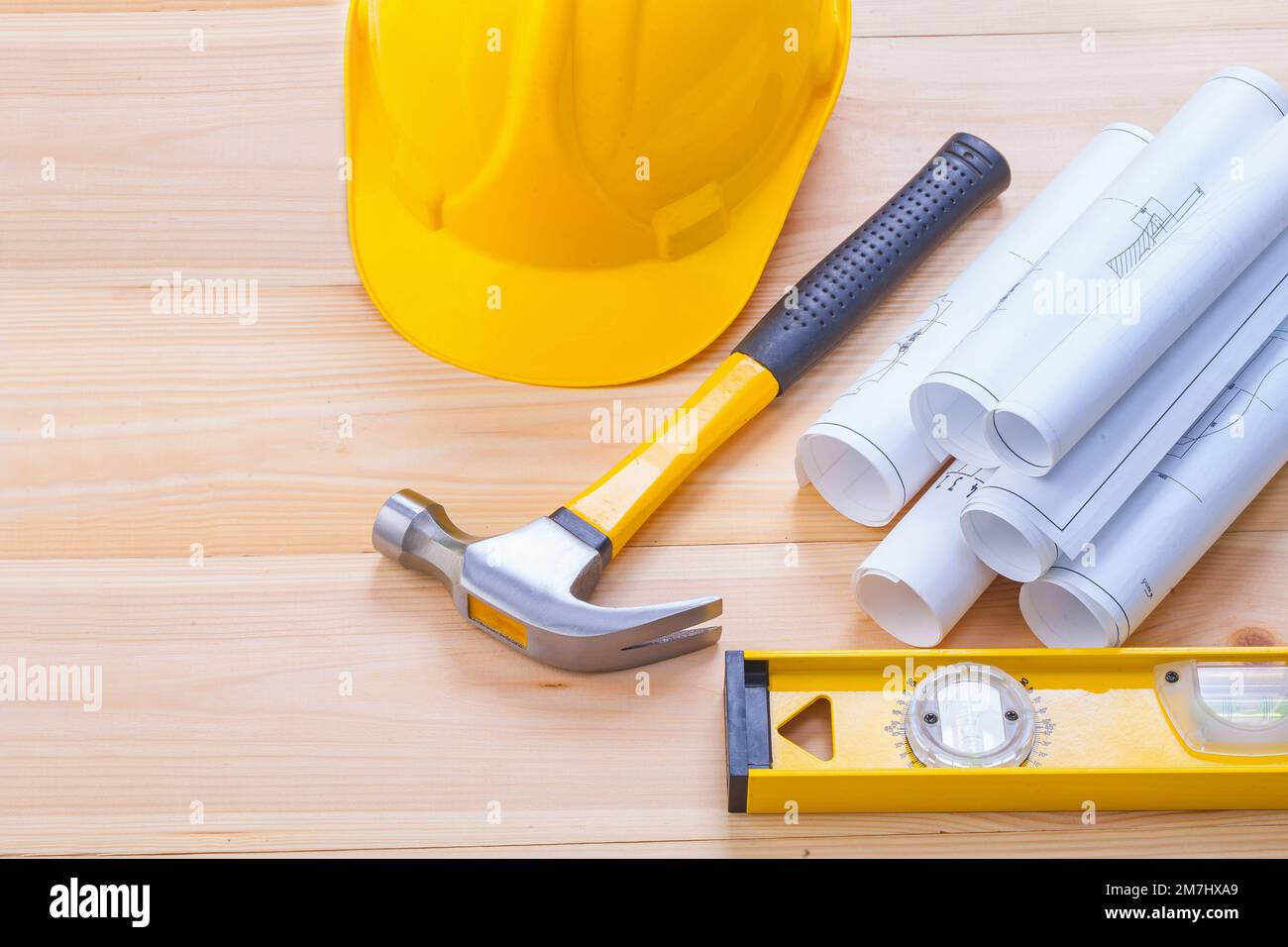 claw hammer stack of white rolled blueprints construction level helmet ...