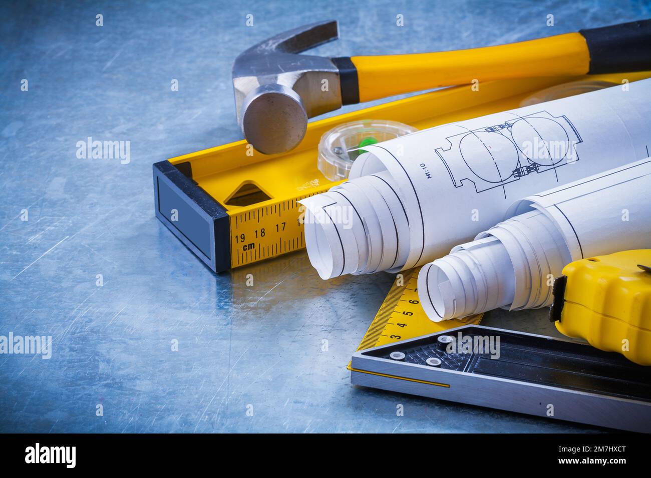 Close up image of hammer measuring line construction plans and level ...