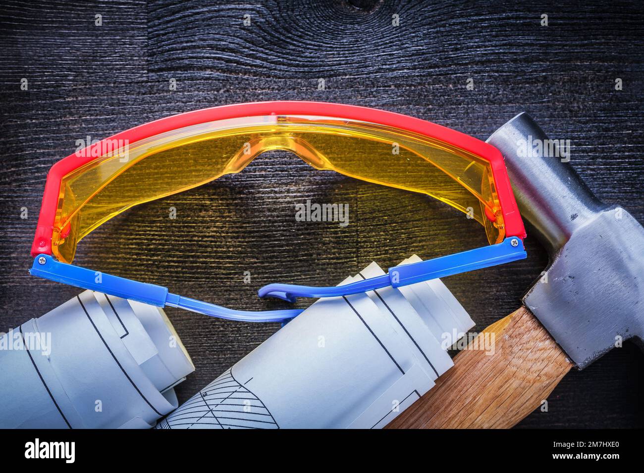 close up view rolled blueprints hammer goggles on wood board Stock ...