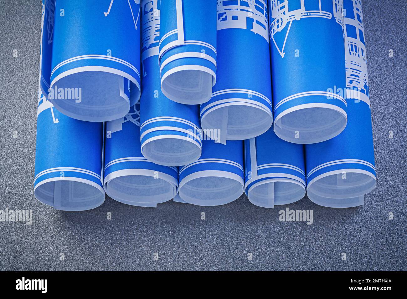Composition of blue rolled up construction drawings on grey background ...