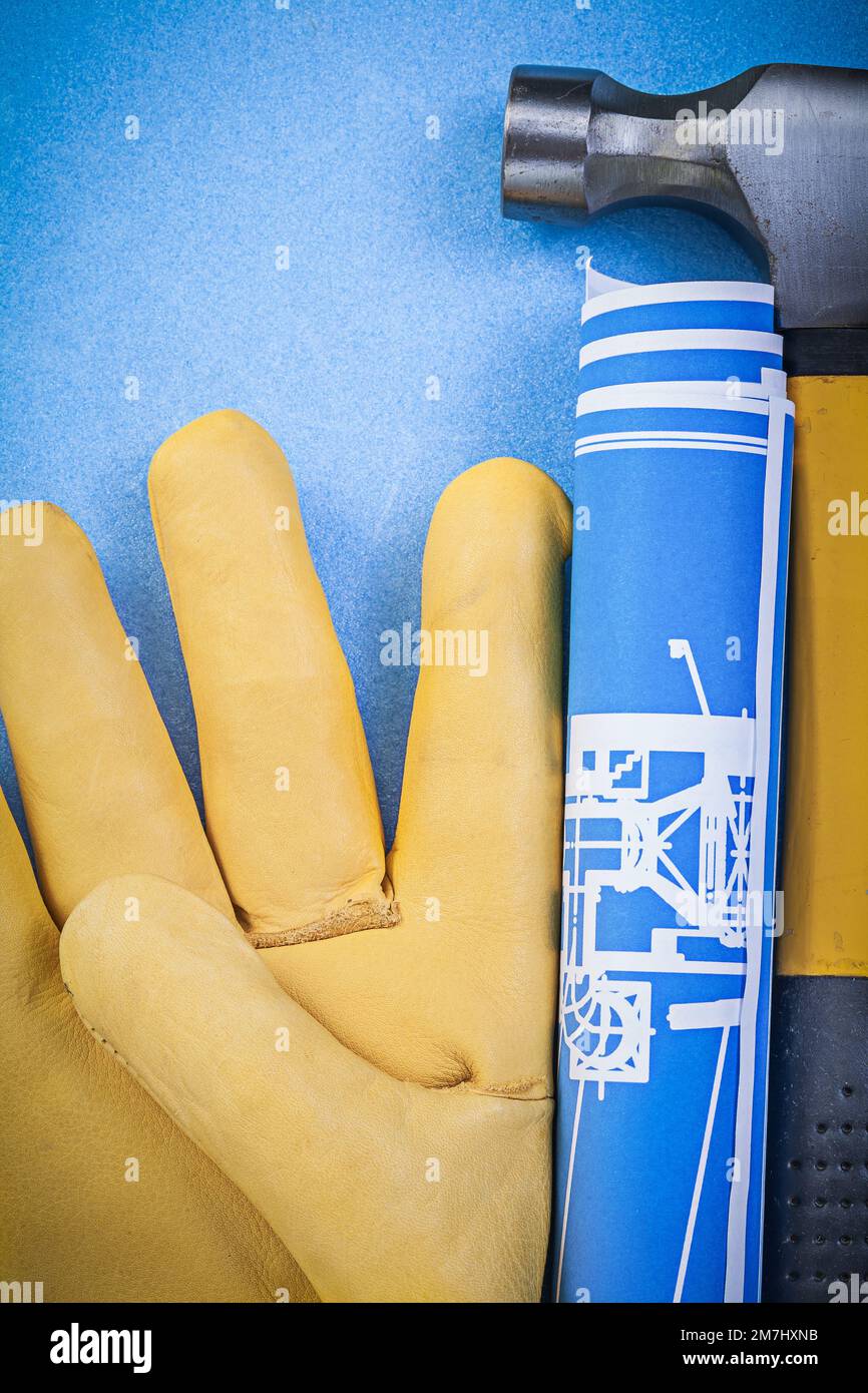 Composition of claw hammer safety gloves blueprints on blue background ...