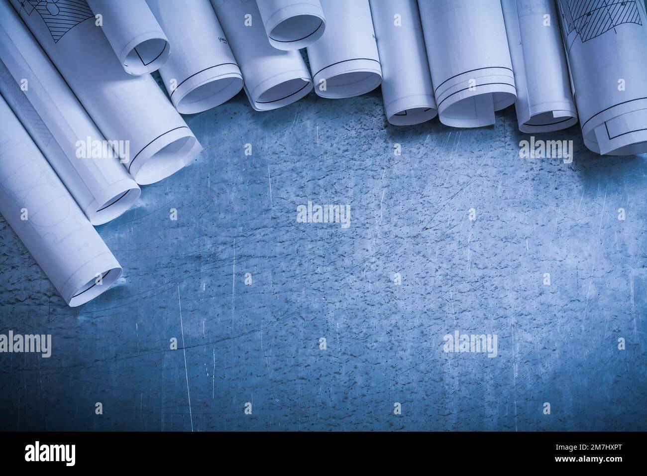 Composition of rolled construction plans on scratched silver-metal ...