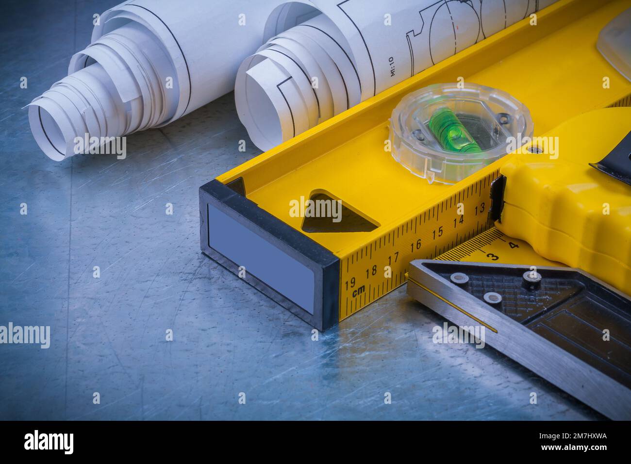 Construction drawings and level tape measure square ruler on metallic ...