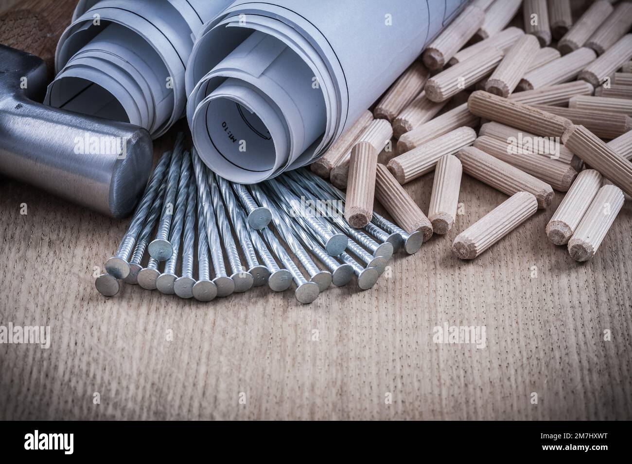 Construction drawings claw hammer pile of woodworking dowels and nails ...
