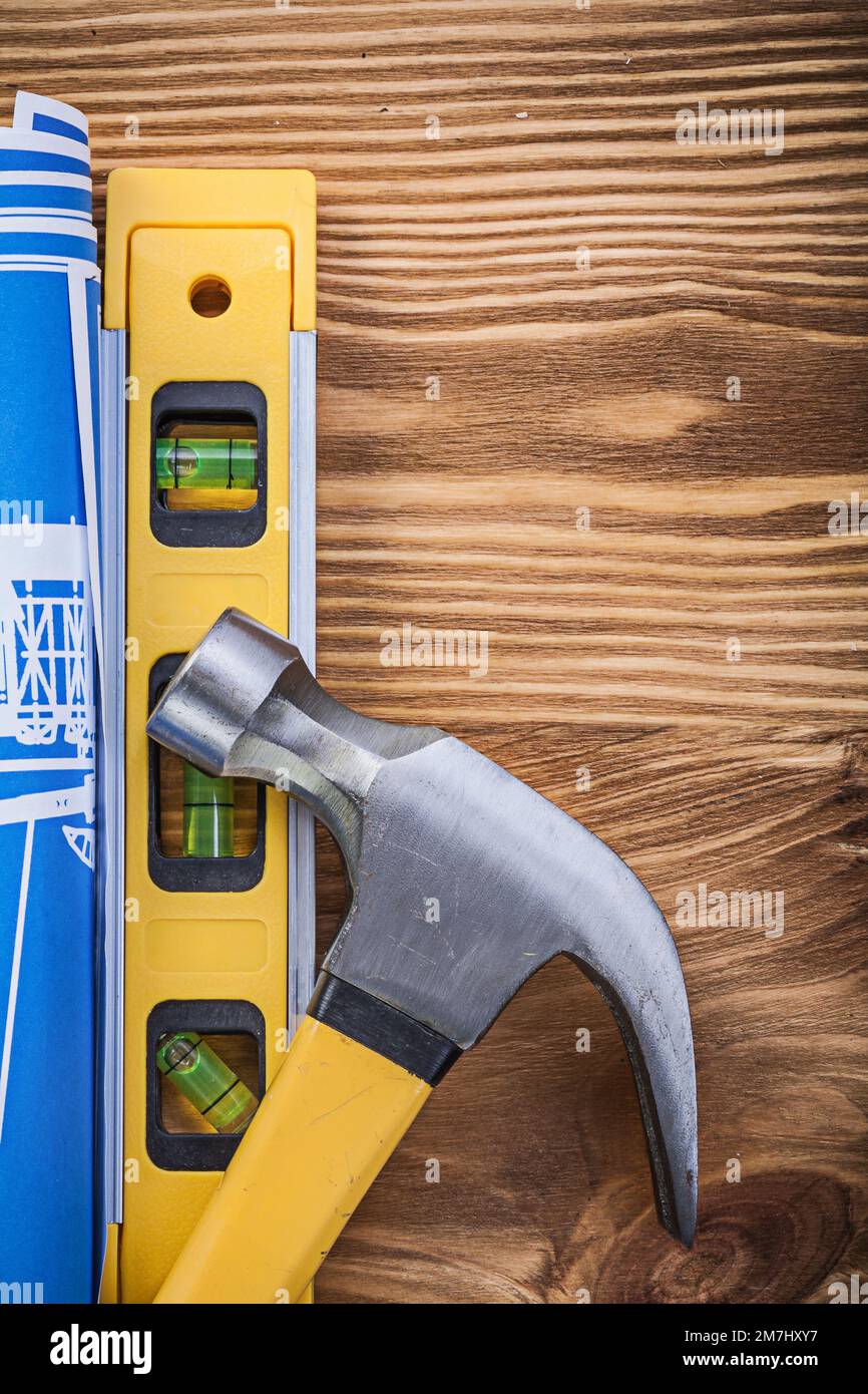 Construction level blue blueprint claw hammer on vintage wood board ...