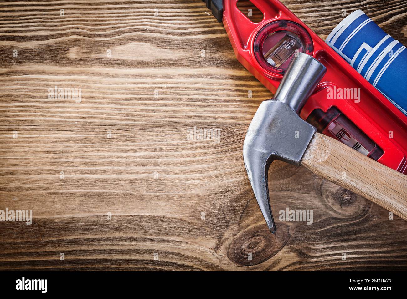 Construction level blue blueprint claw hammer on vintage wood board ...