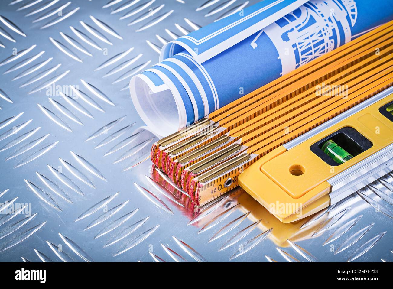 Construction level wooden meter blue blueprints on fluted metal sheet ...