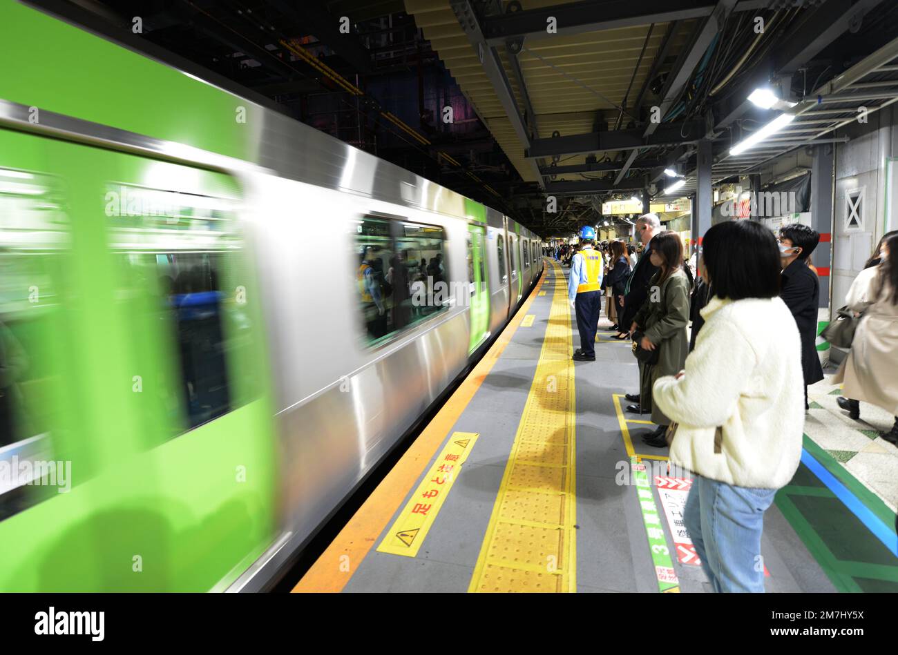 Japanese Passengers Waiting For The Jr Yamanote Line In Tokyo, Japan