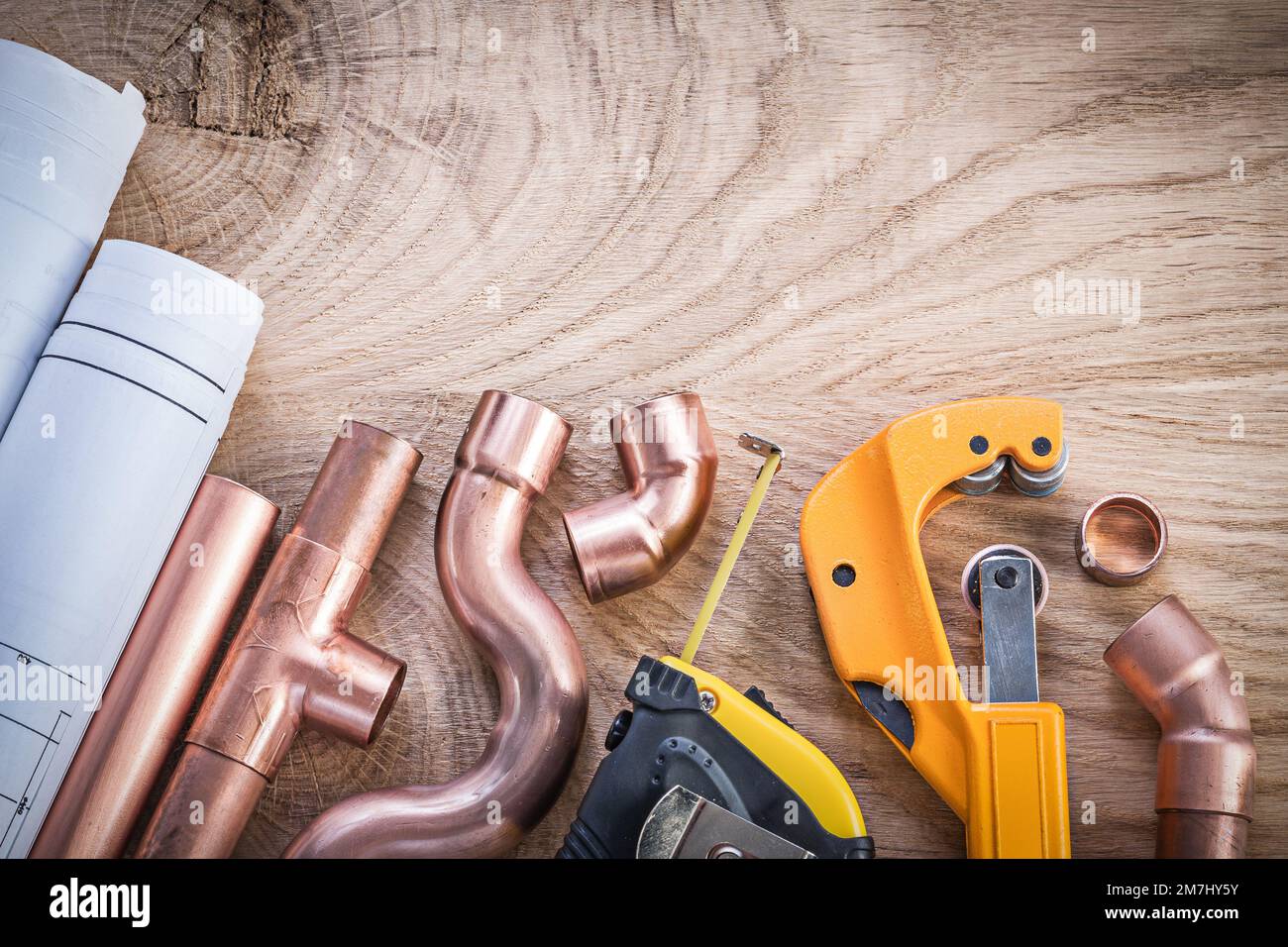 Construction plans measuring tape water pipe cutter connectors on wood ...